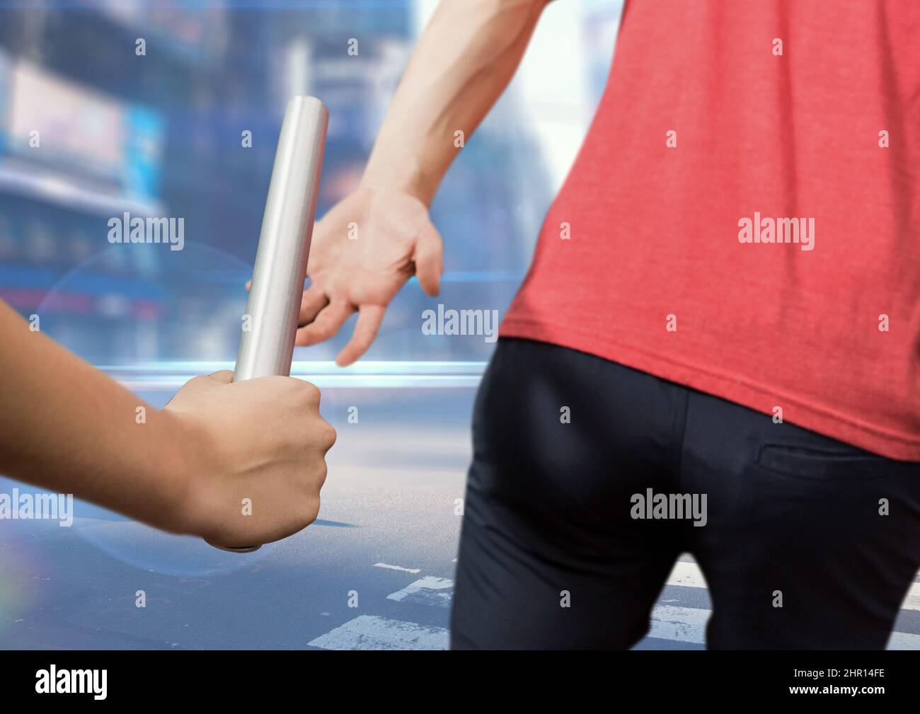 Composite image of hand passing a baton to male athlete against street ...