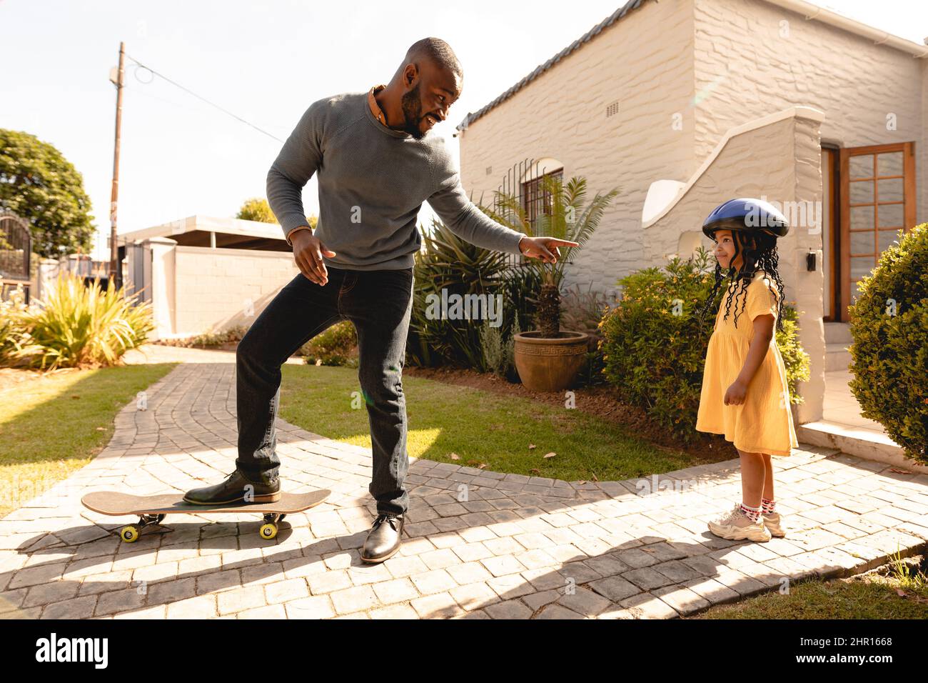 African american father pointing at daughter while teaching her ...
