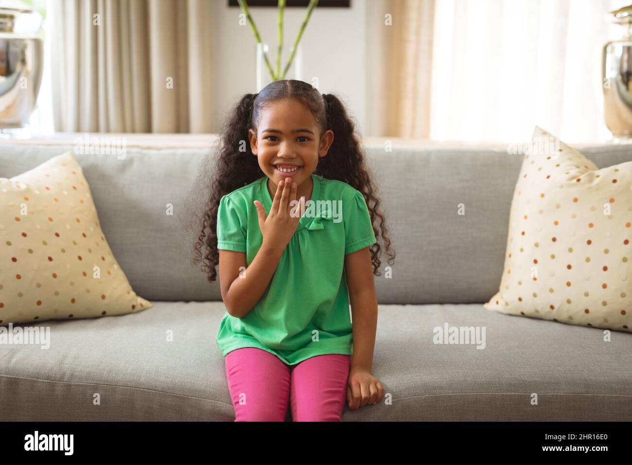 Portrait of smiling biracial mute girl talking through hand sign ...