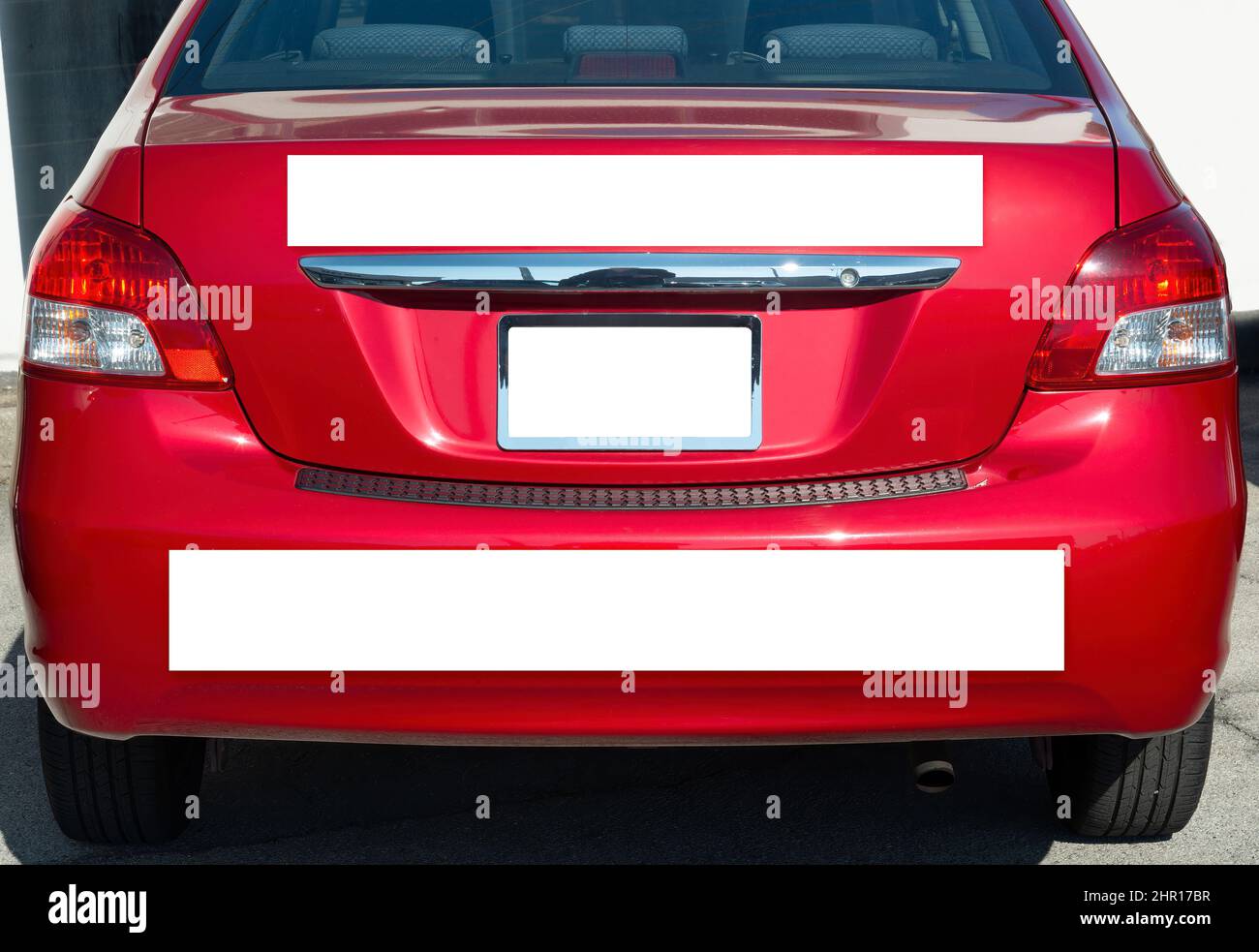 Horizontal close-up shot of the rear end of a small generic red car ...
