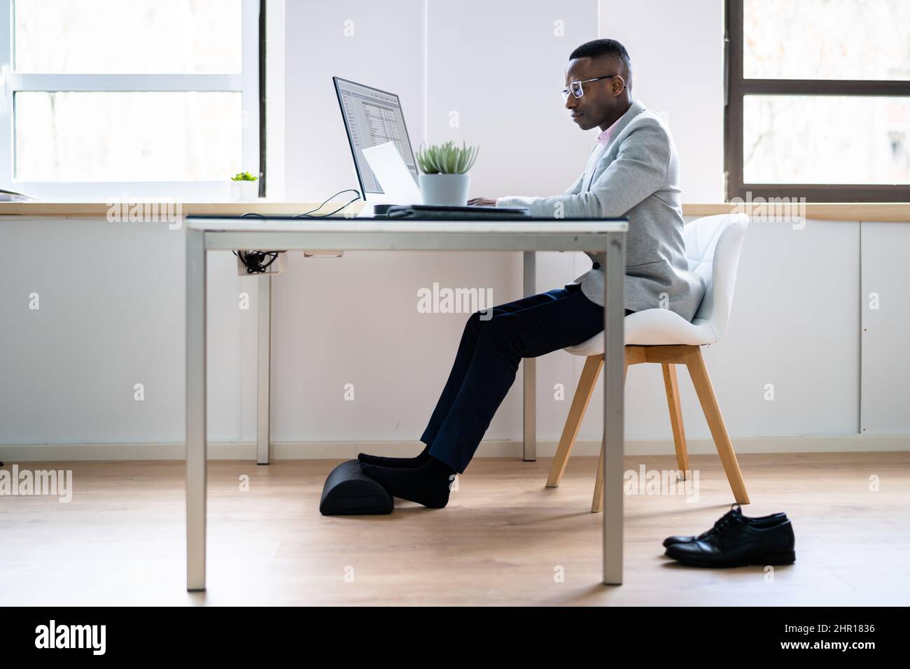 Worker Using Footrest To Reduce Back Strain And Feet Fatigue Stock ...