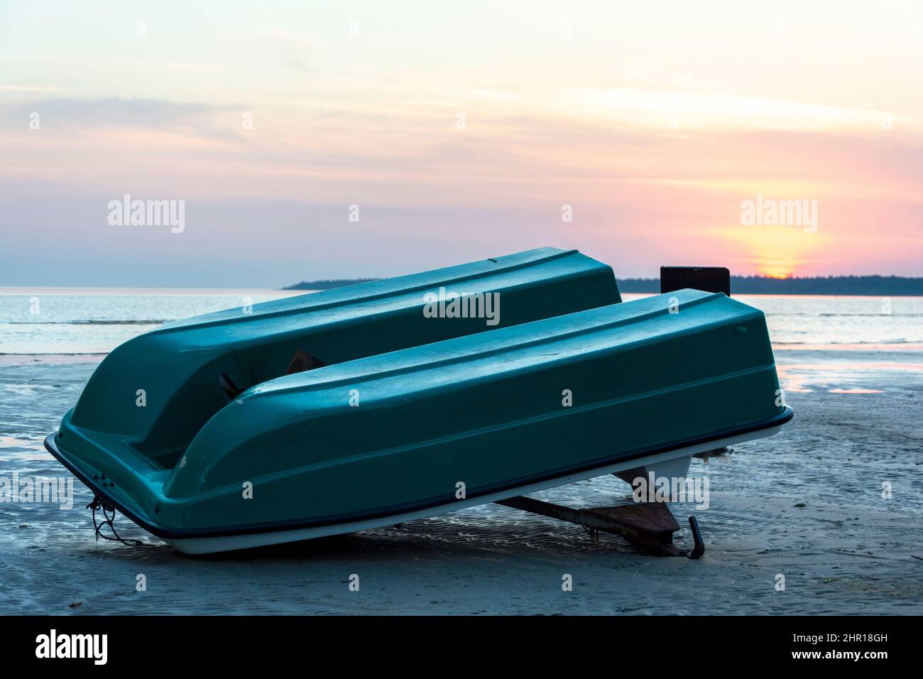an old plastic inverted boat on the shore of the sea bay, an old ...