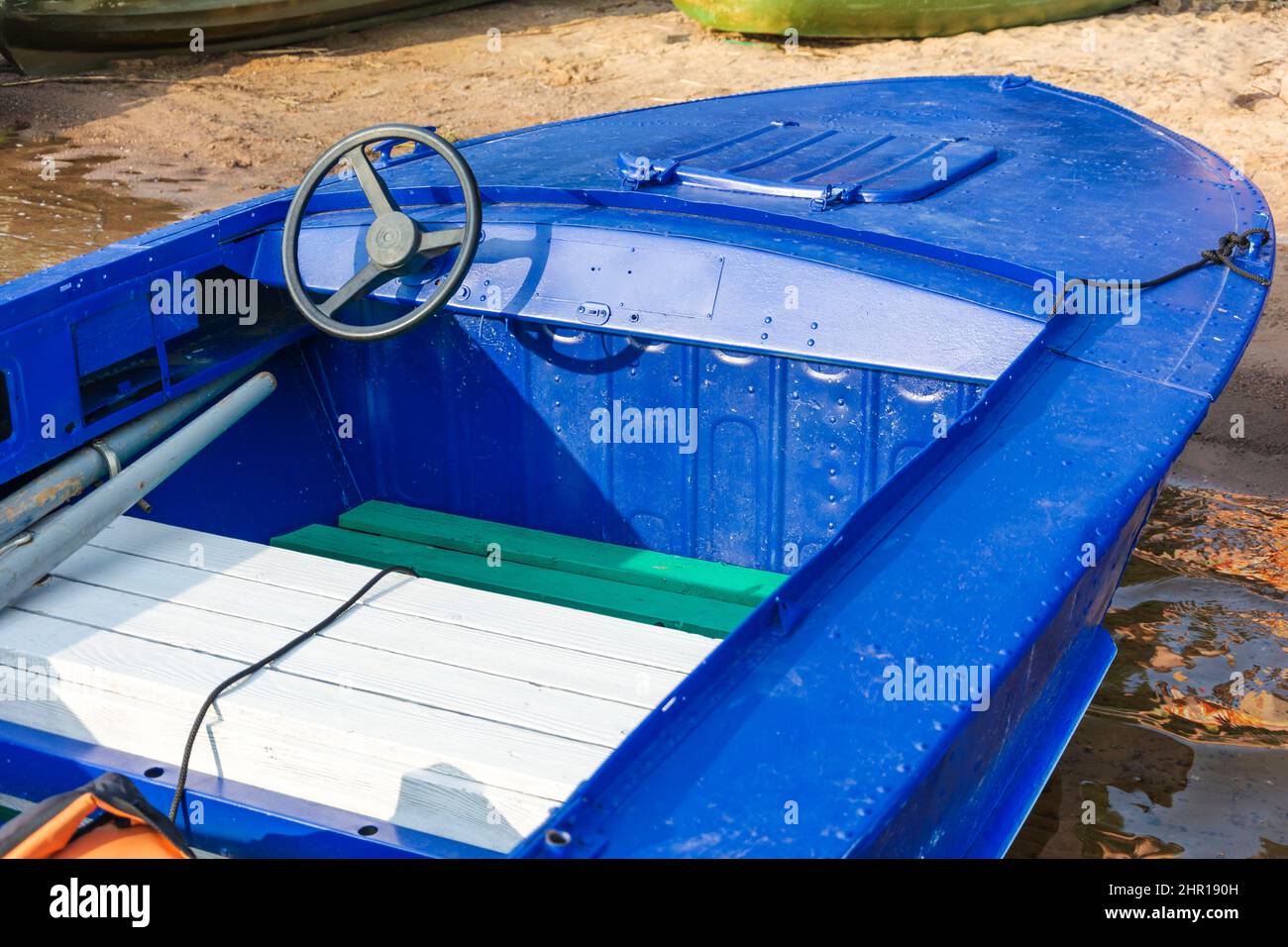 Aluminum blue fishing boat with a motor near the lake shore, fishing ...