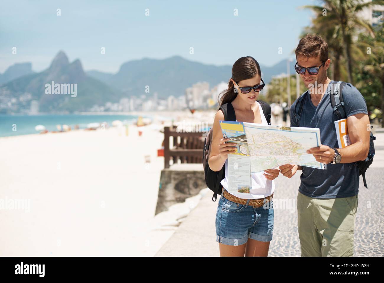 Getting lost in paradise isnt so bad. Shot of a young couple looking at ...