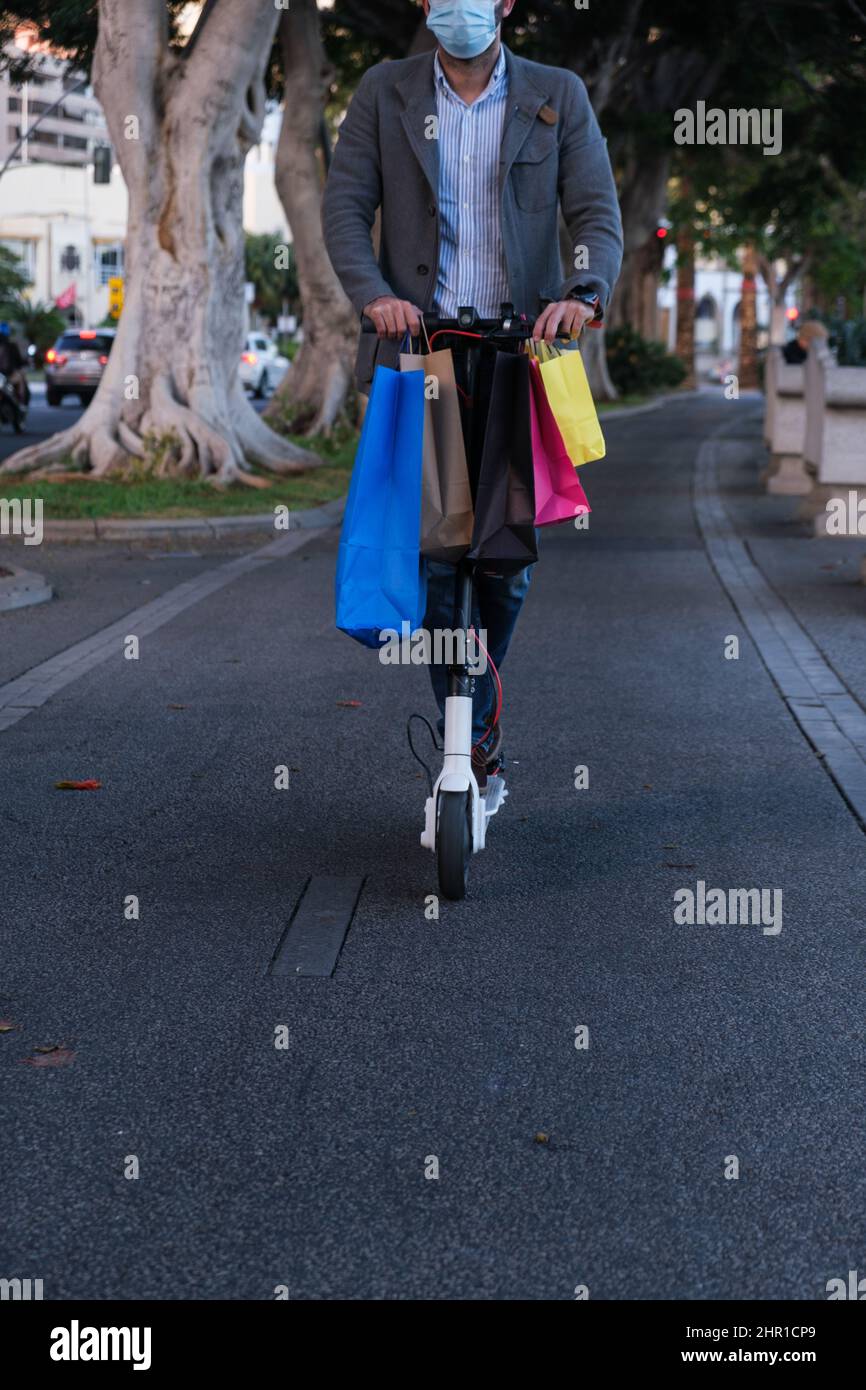 Man carrying paper bags on the electric scooter Stock Photo - Alamy