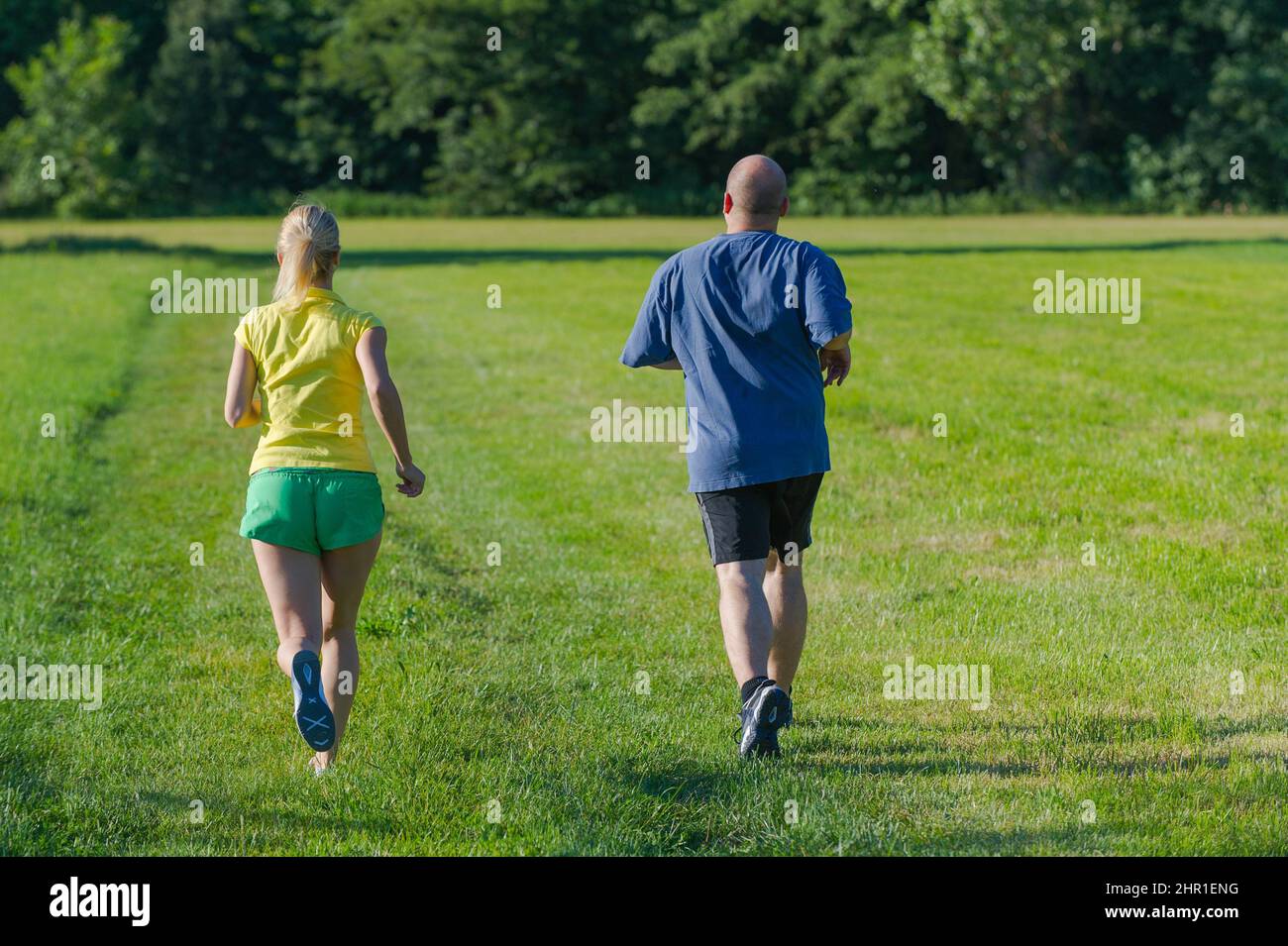 pair jogging together across a meadow, rear view Stock Photo - Alamy
