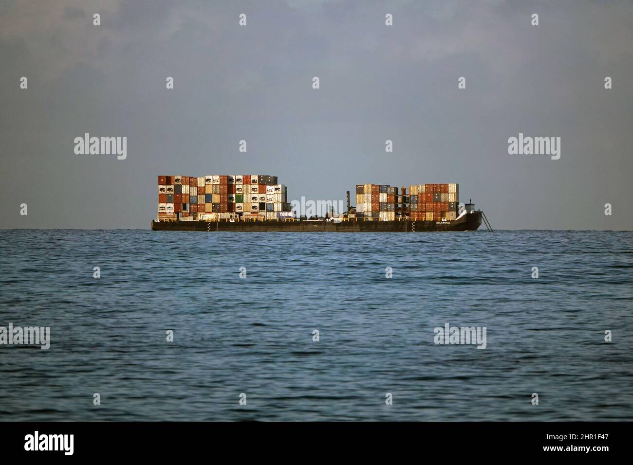 A cargo ship with many containers sails on the ocean off the coast of ...