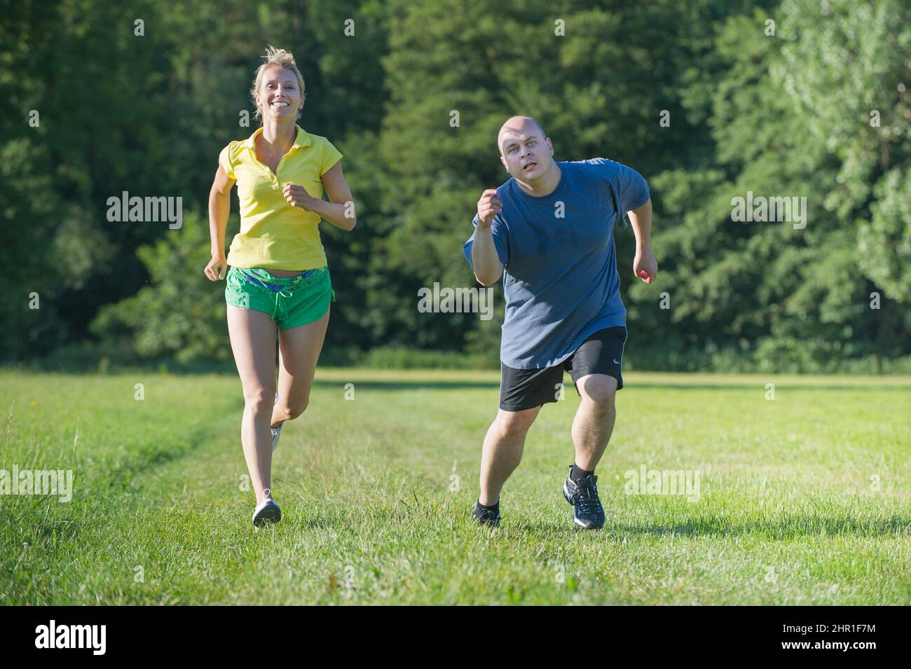 pair jogging together across a meadow, front view Stock Photo - Alamy