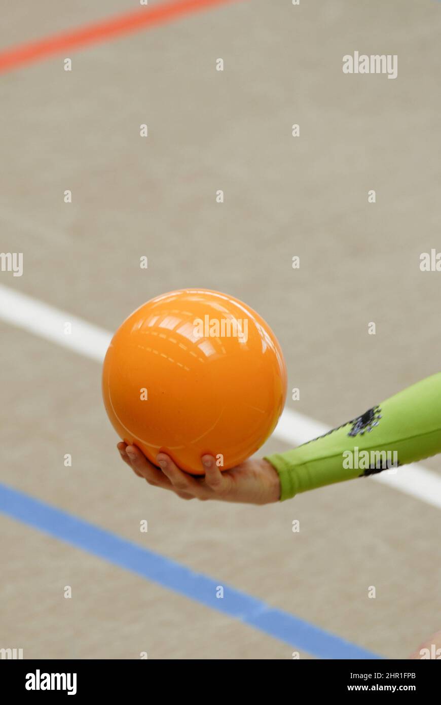 orange exercise ball on a hand, rhythmic gymnastics Stock Photo - Alamy
