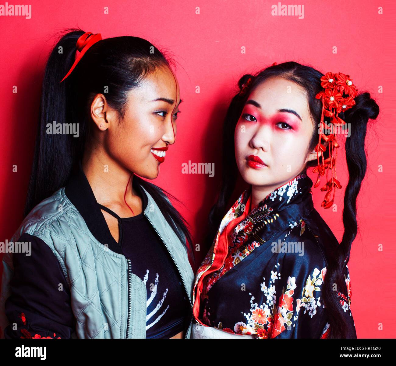 two pretty geisha friends: modern asian woman and traditional wearing ...