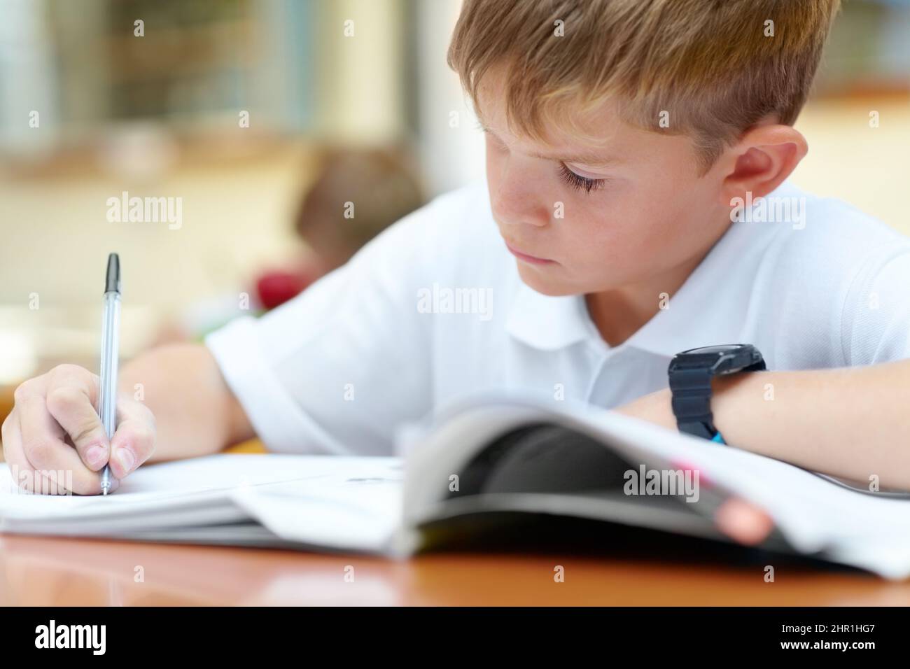 Hes making sure all his work is done. Two young schoolboys doing their ...