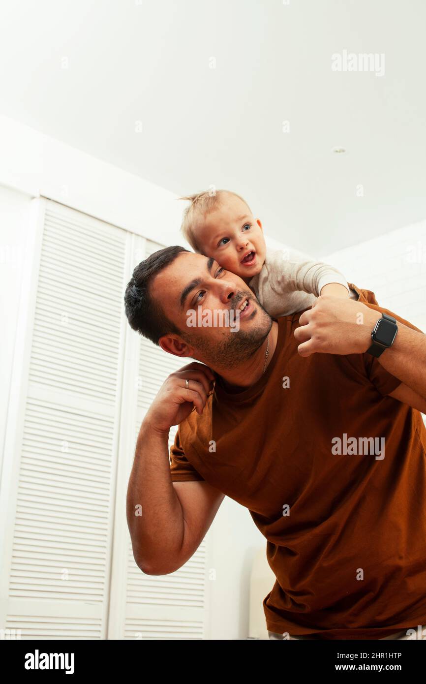 young real father with little cute son toddler on kitchen in morning ...