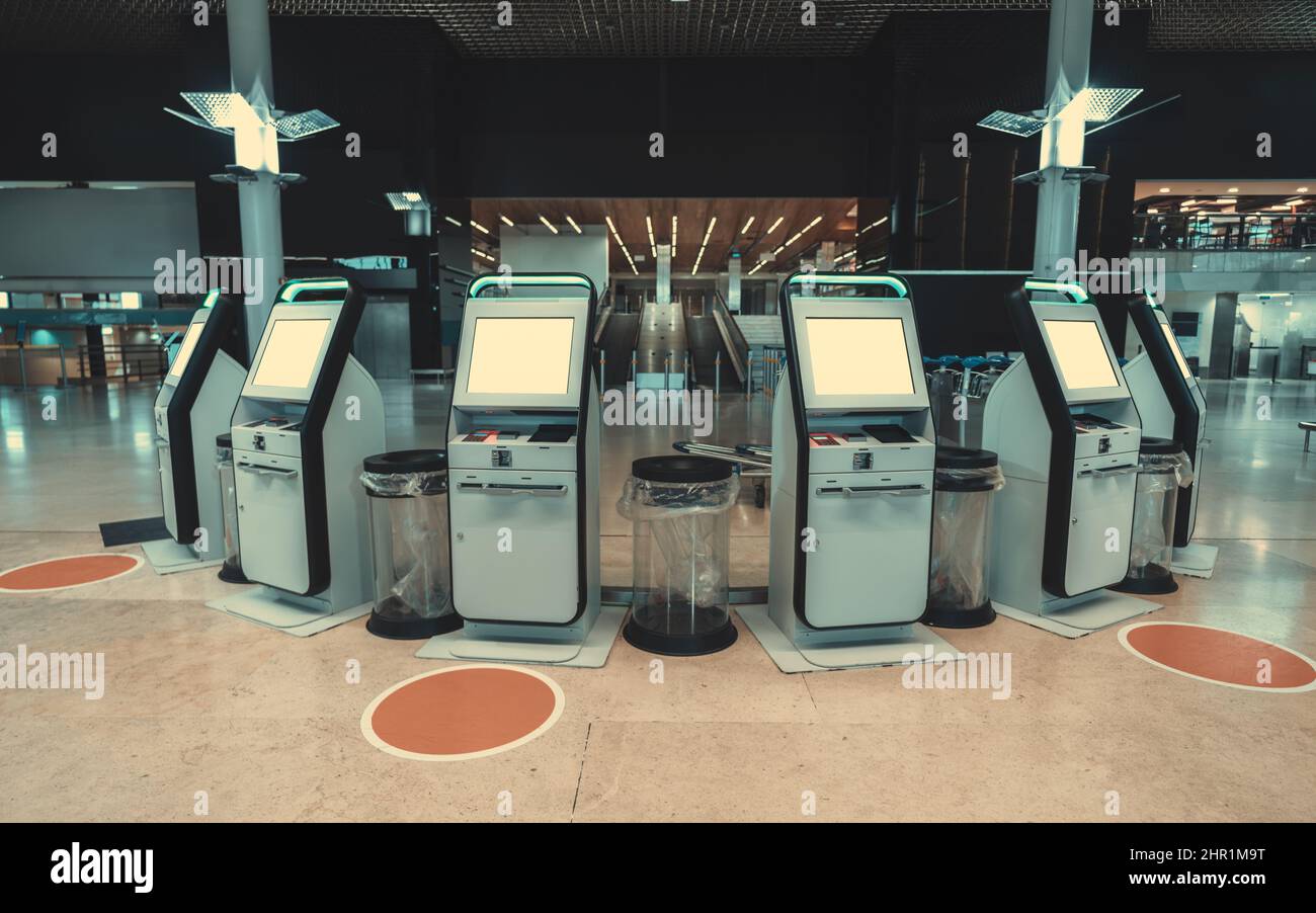 A rounded row of self-serve flight check-in electronic machines in a ...