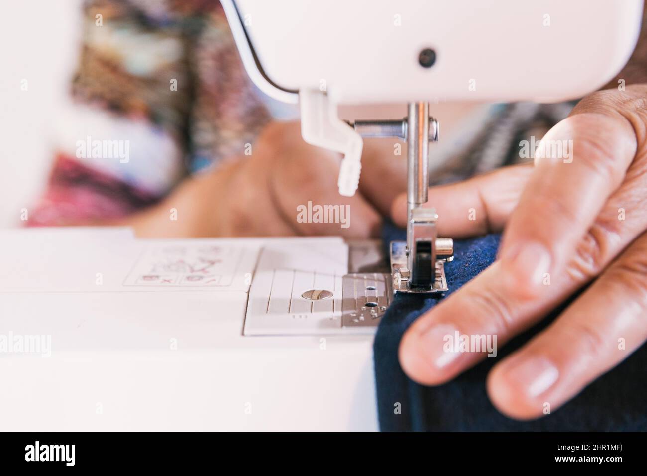 unrecognizable woman using a sewing machine to manufacture clothing ...