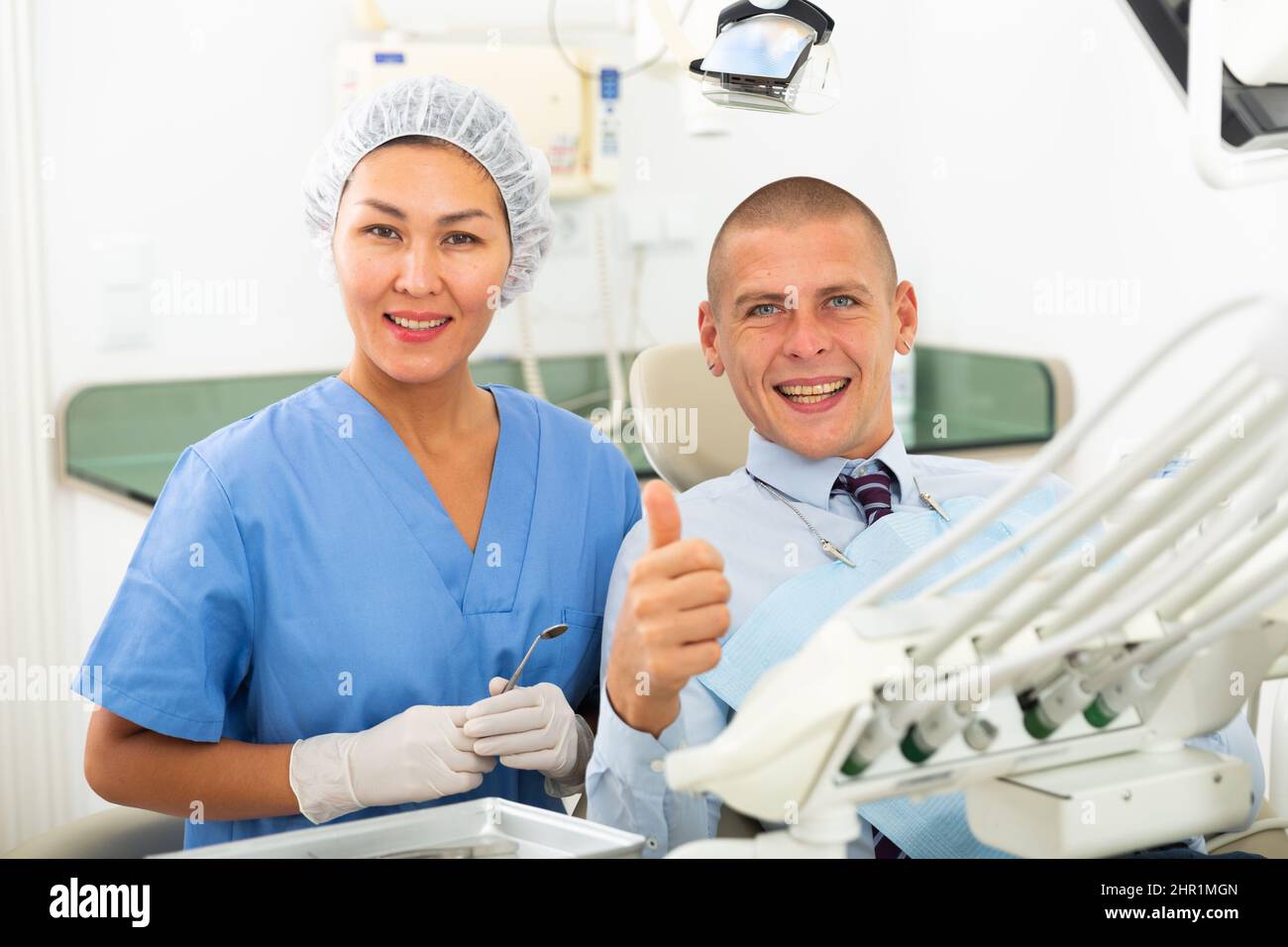 Satisfied patient visiting dentist giving thumbs up Stock Photo - Alamy