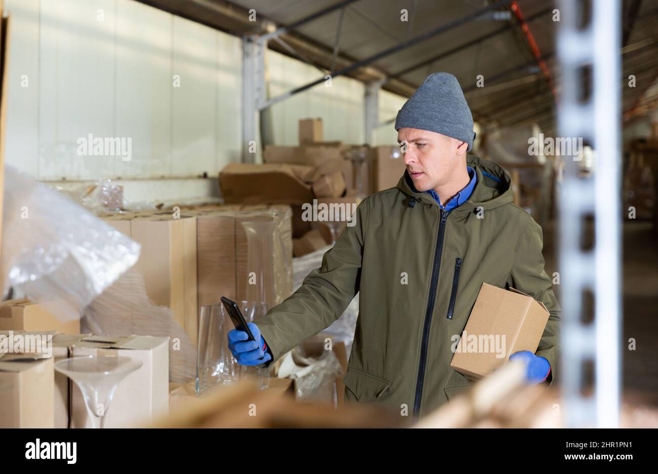 Warehouse worker using his smartphone to take photographs Stock Photo ...