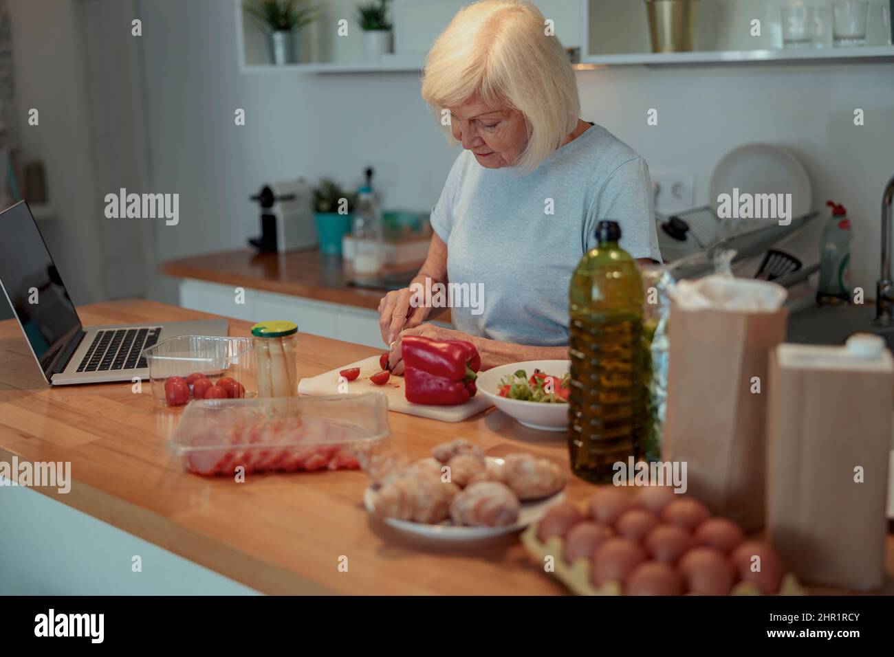 Pensioner female cooking in kitchen at home Stock Photo - Alamy