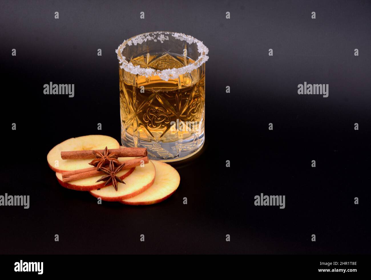 Crystal glass of apple cider with sugar on the rim, pieces of ripe ...