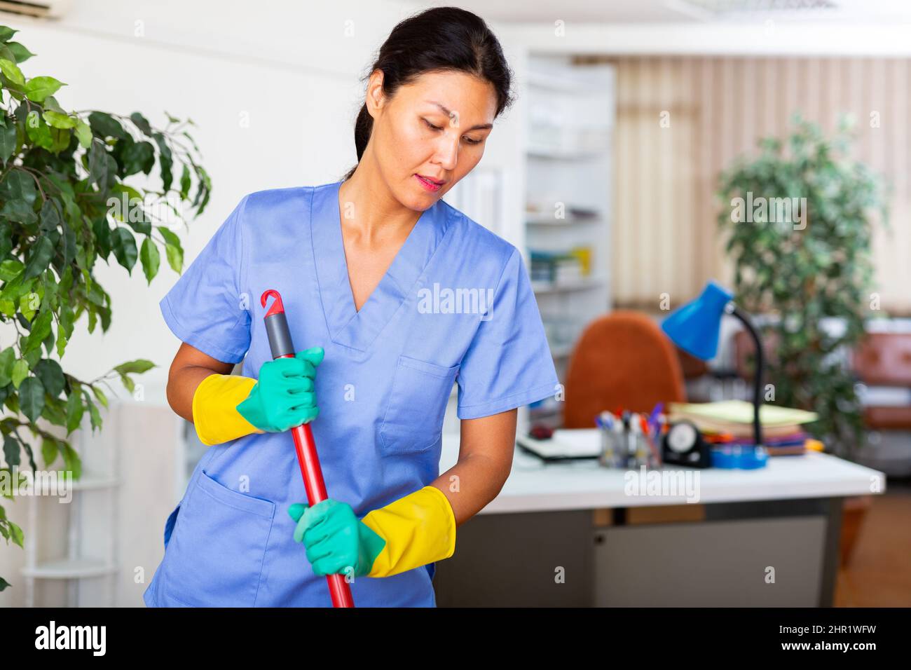 Woman wiping office floor with mop Stock Photo - Alamy
