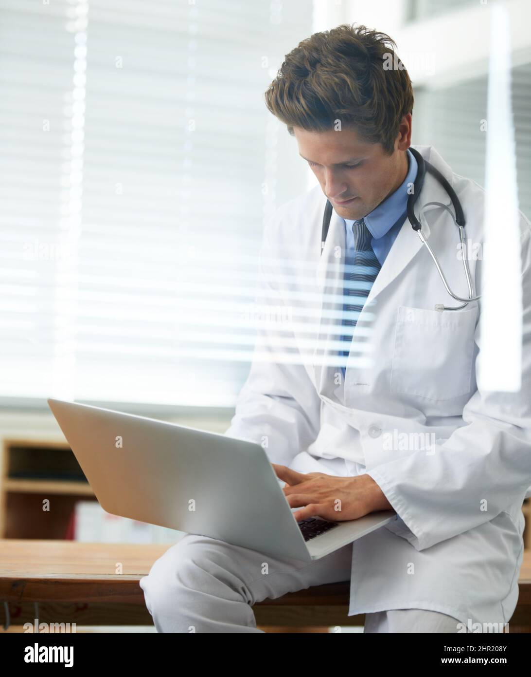 Working hard for his patients.... Through the window shot of a young ...