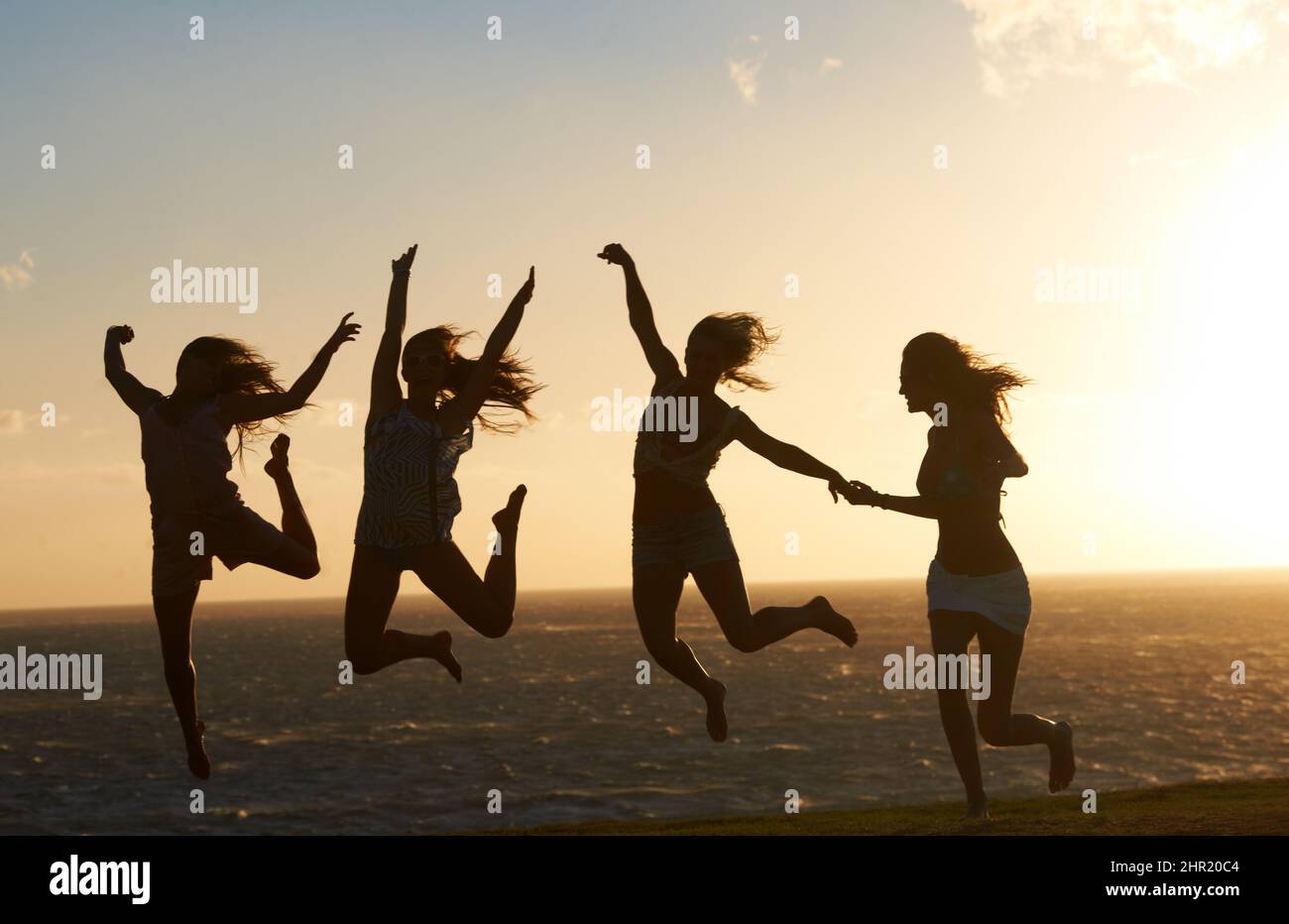 Feeling on top of the world. Silhouette of a group of girlfriends on ...
