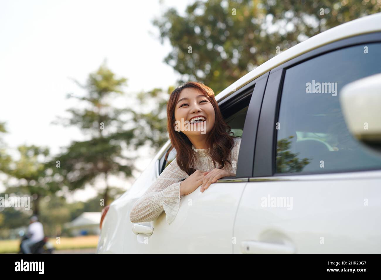 Young tourist woman riding in a taxi in the back seat, and leaning out ...