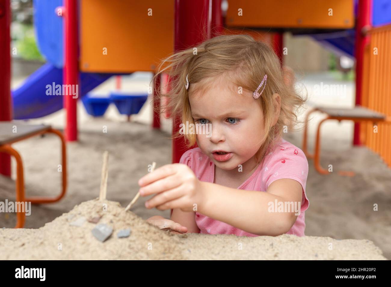 Little kid playing with sand at playground. Small girl at sandbox in ...