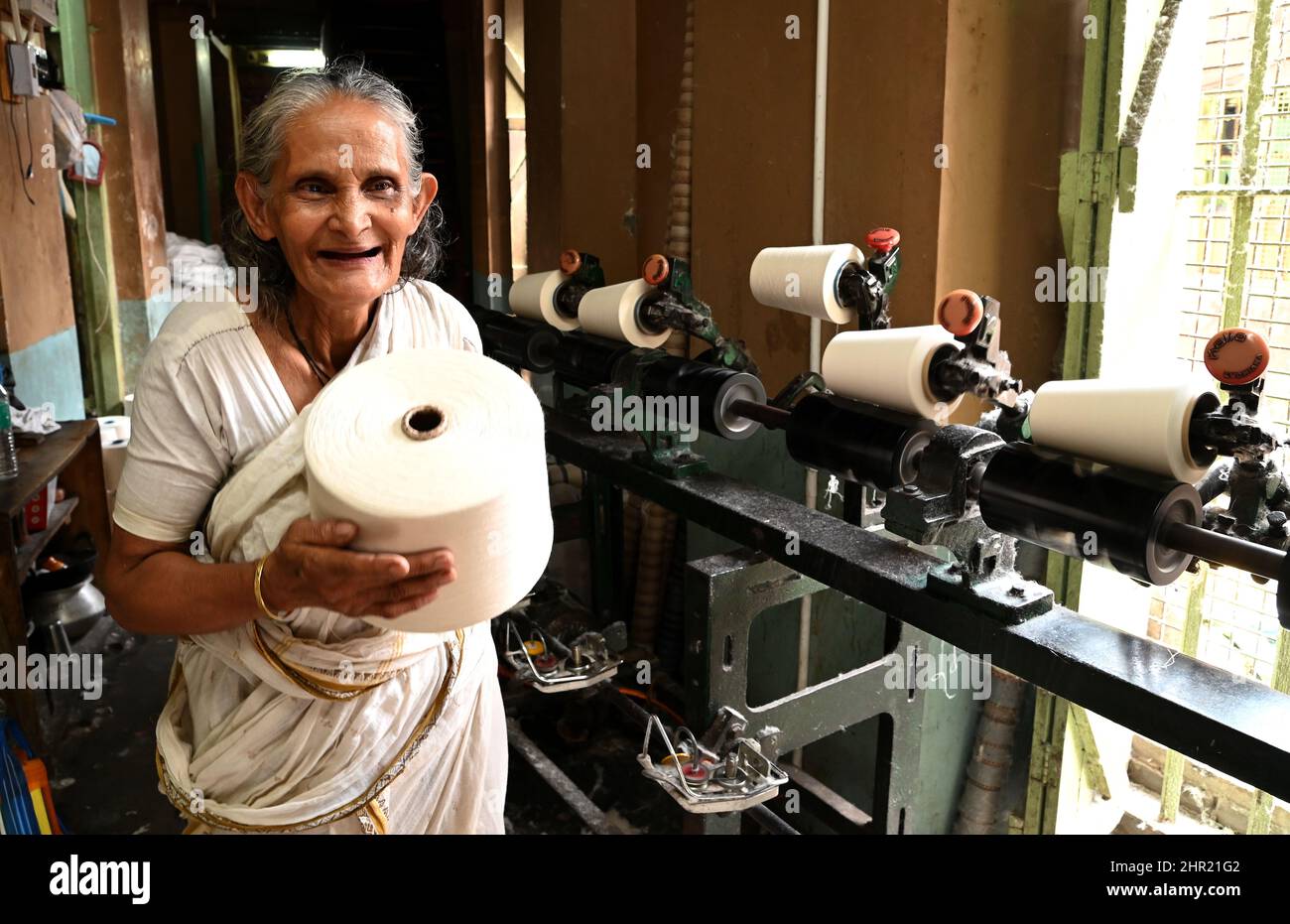 An octogenarian woman working in the textile factory dedicated to ...