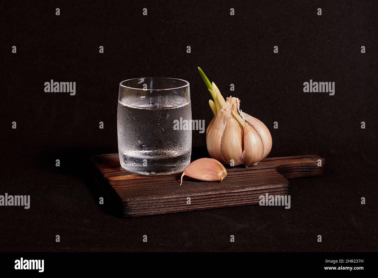 A glass of vodka, a sprouted head of garlic and a clove of garlic Stock ...