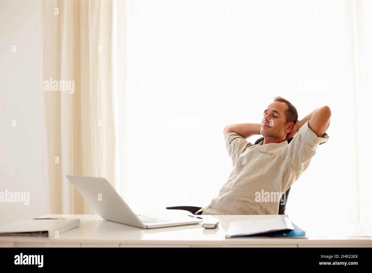Kick back in-between deadlines. Businessman at work taking a minute to ...