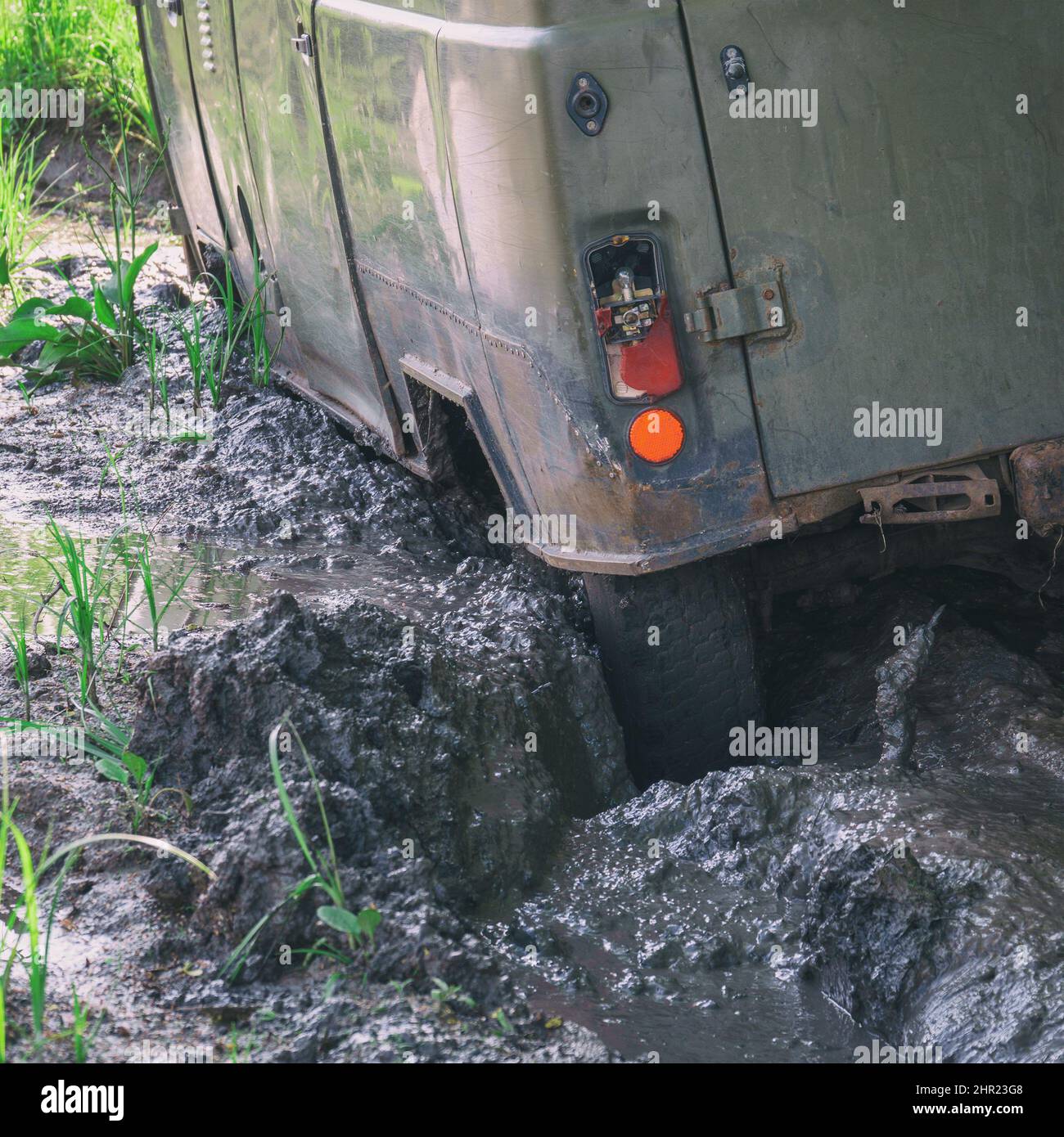 The wheel of an SUV stuck in deep mud on an impassable country road ...