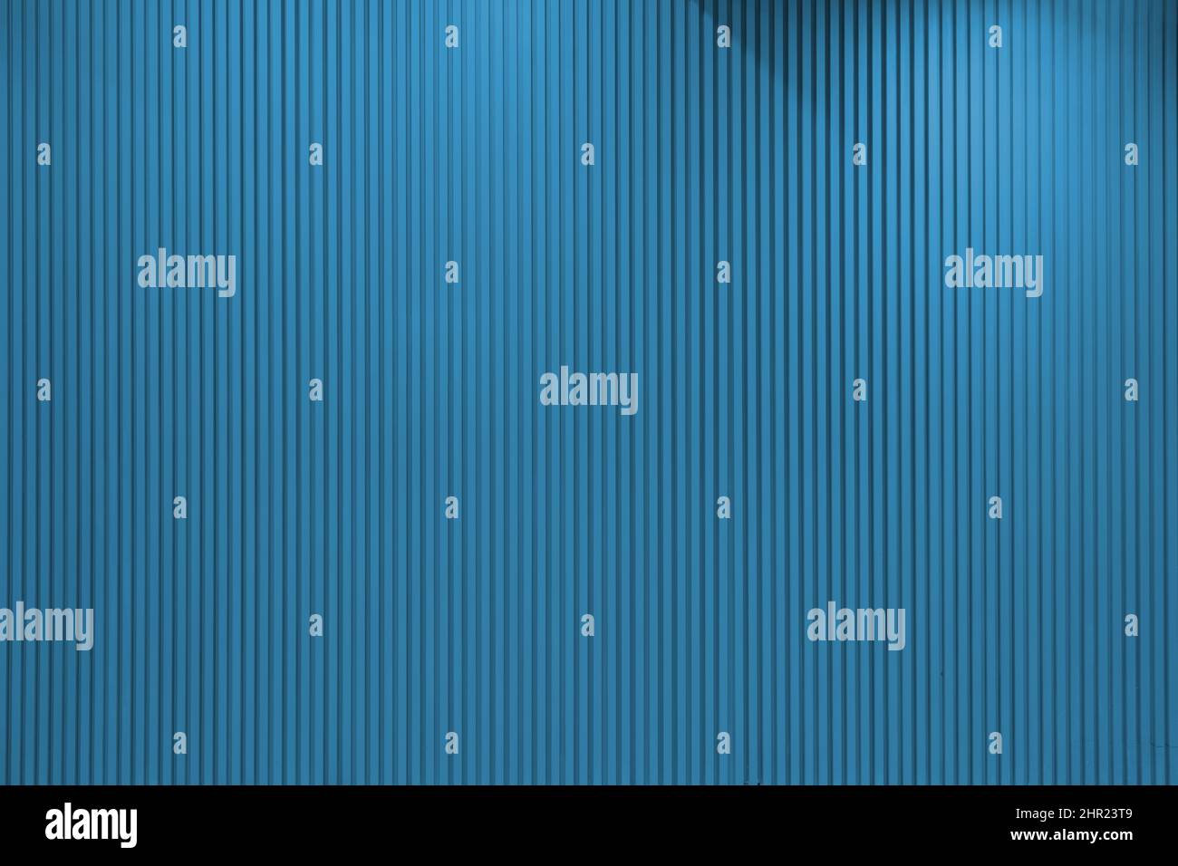 Vertical line textured blue wall with lights hitting it from different ...