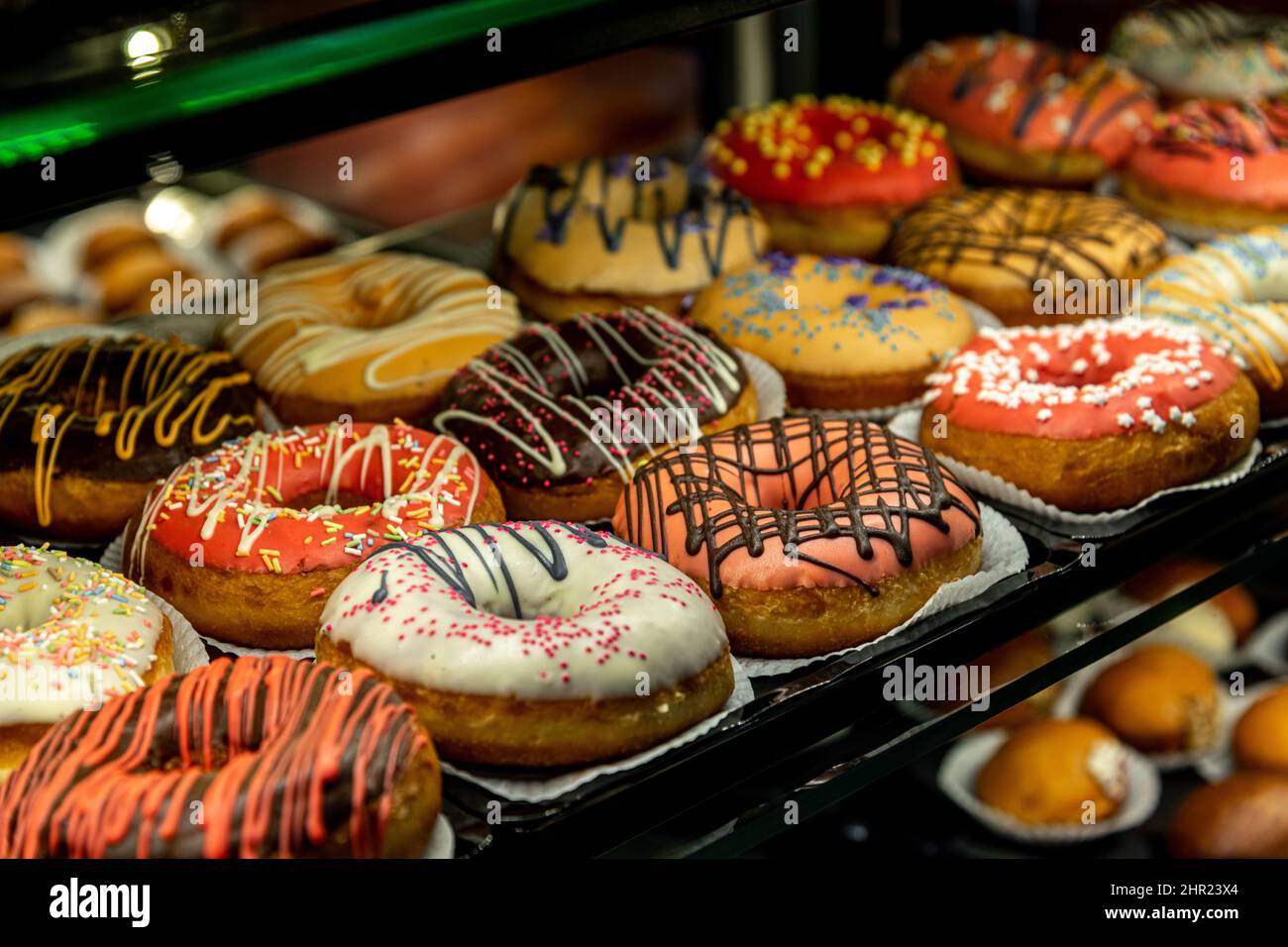 Delicious donuts decorated with different decorations displayed in cafe ...