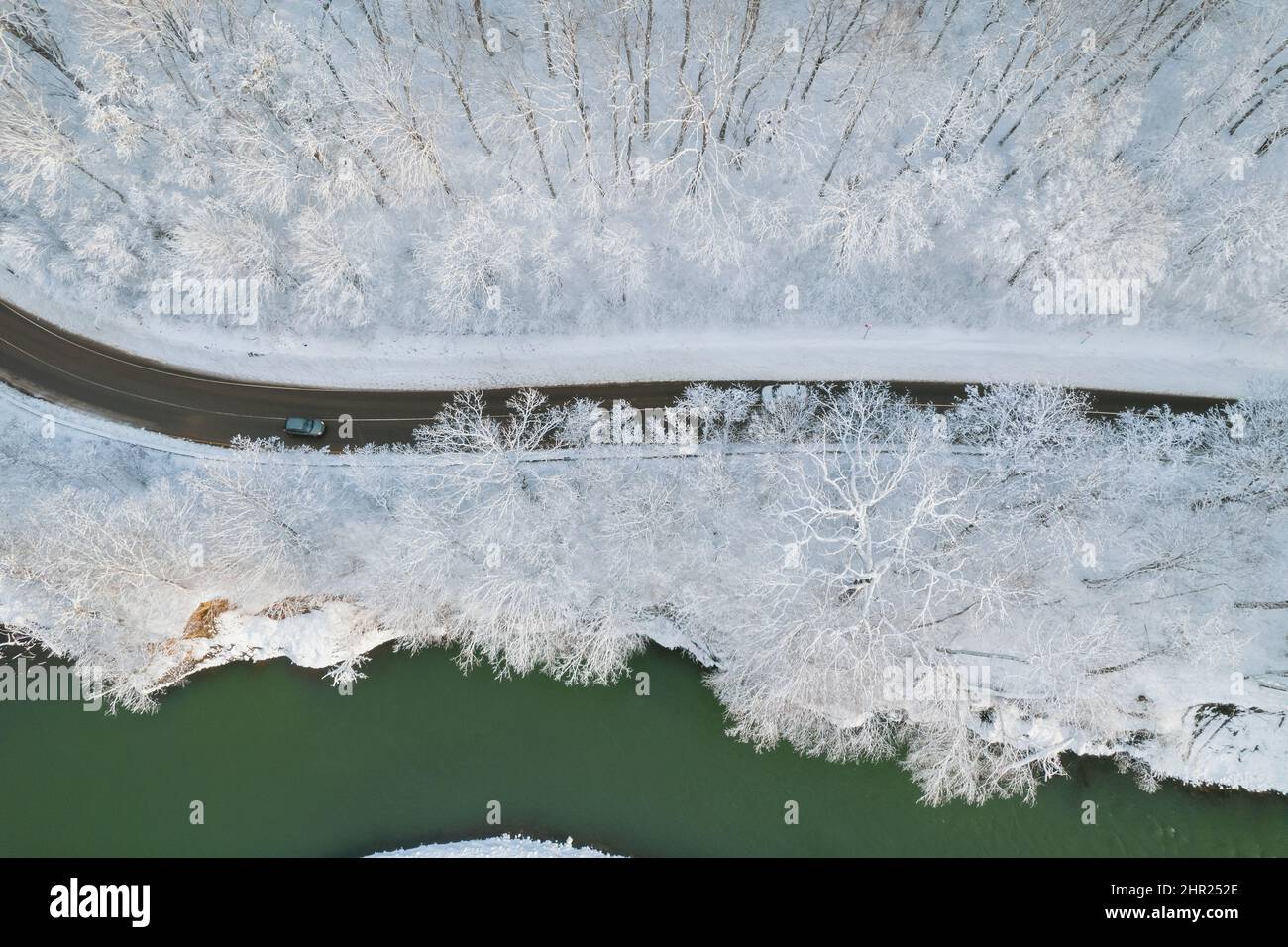 Aerial top down cinematic winter snow cowered country road, asphalt ...