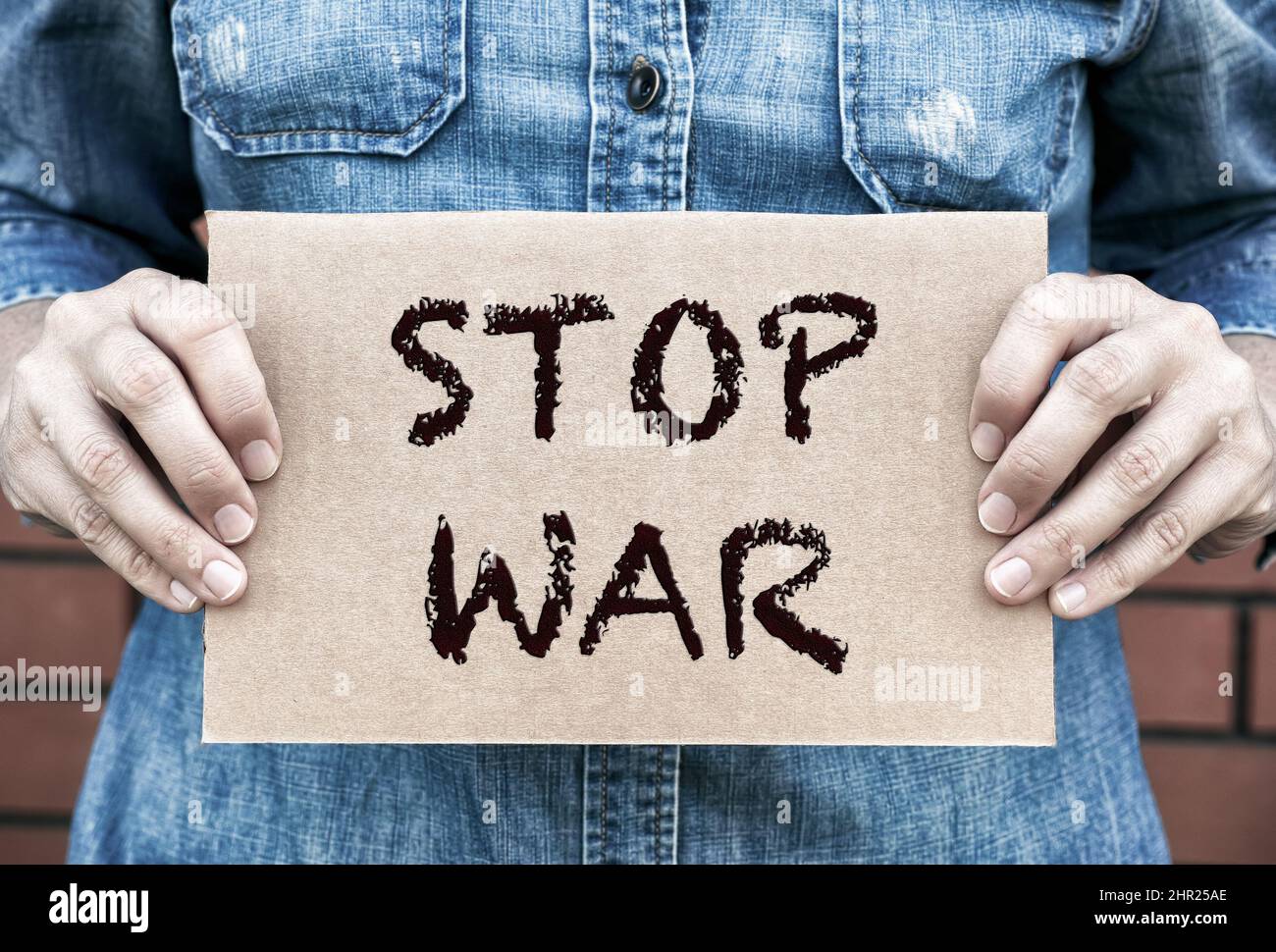 Woman hands holding piece of cardboard with words Stop War against ...
