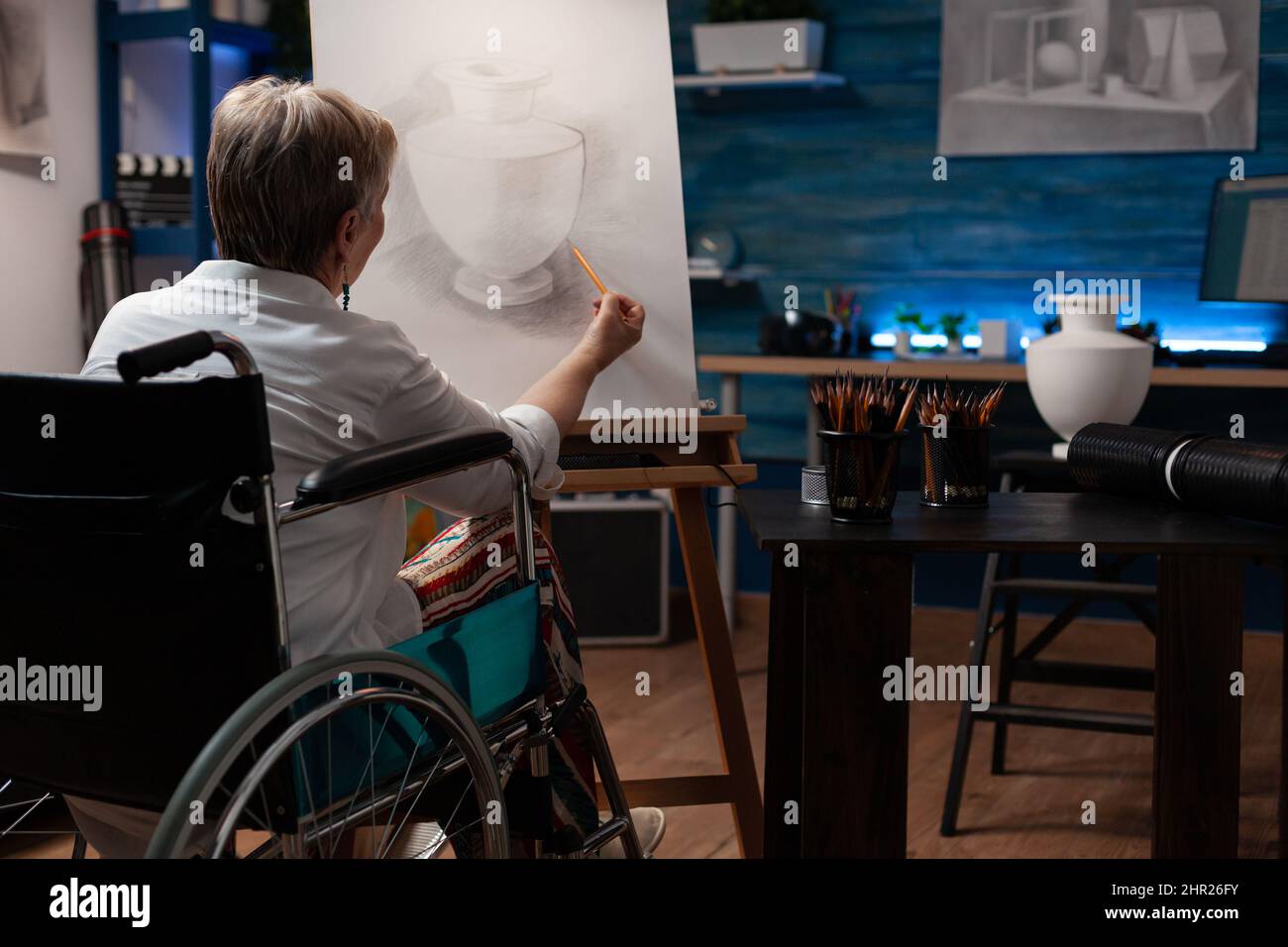 Focused retired art teacher living with disability doing creative ...