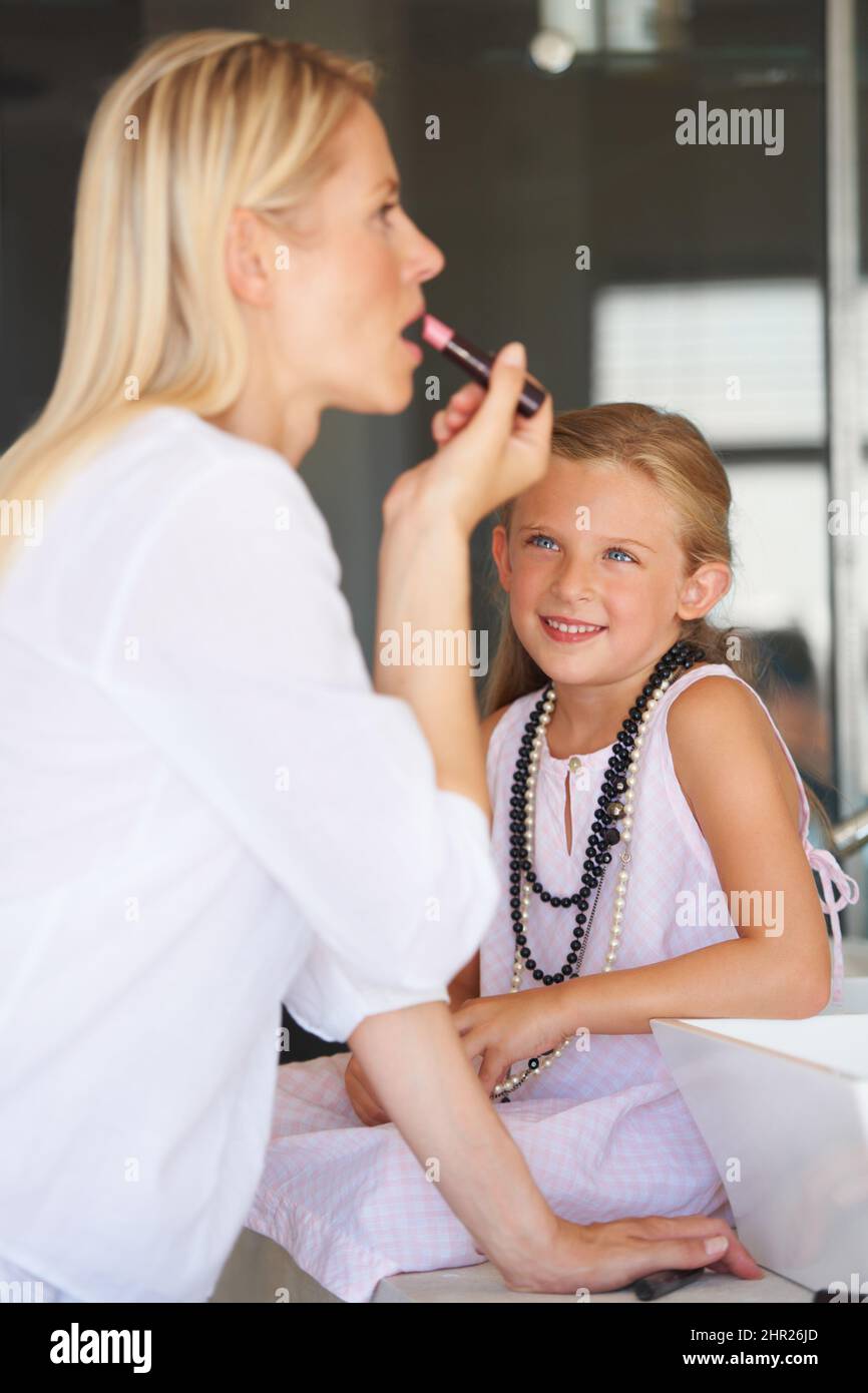 I cant wait to be a grown-up. Little girl watching her mother apply her ...