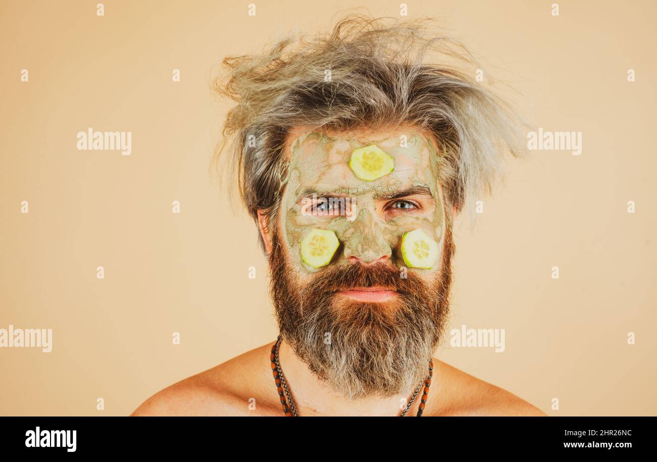 Man with clay mask and cucumber slices on face. Spa, dermatology ...