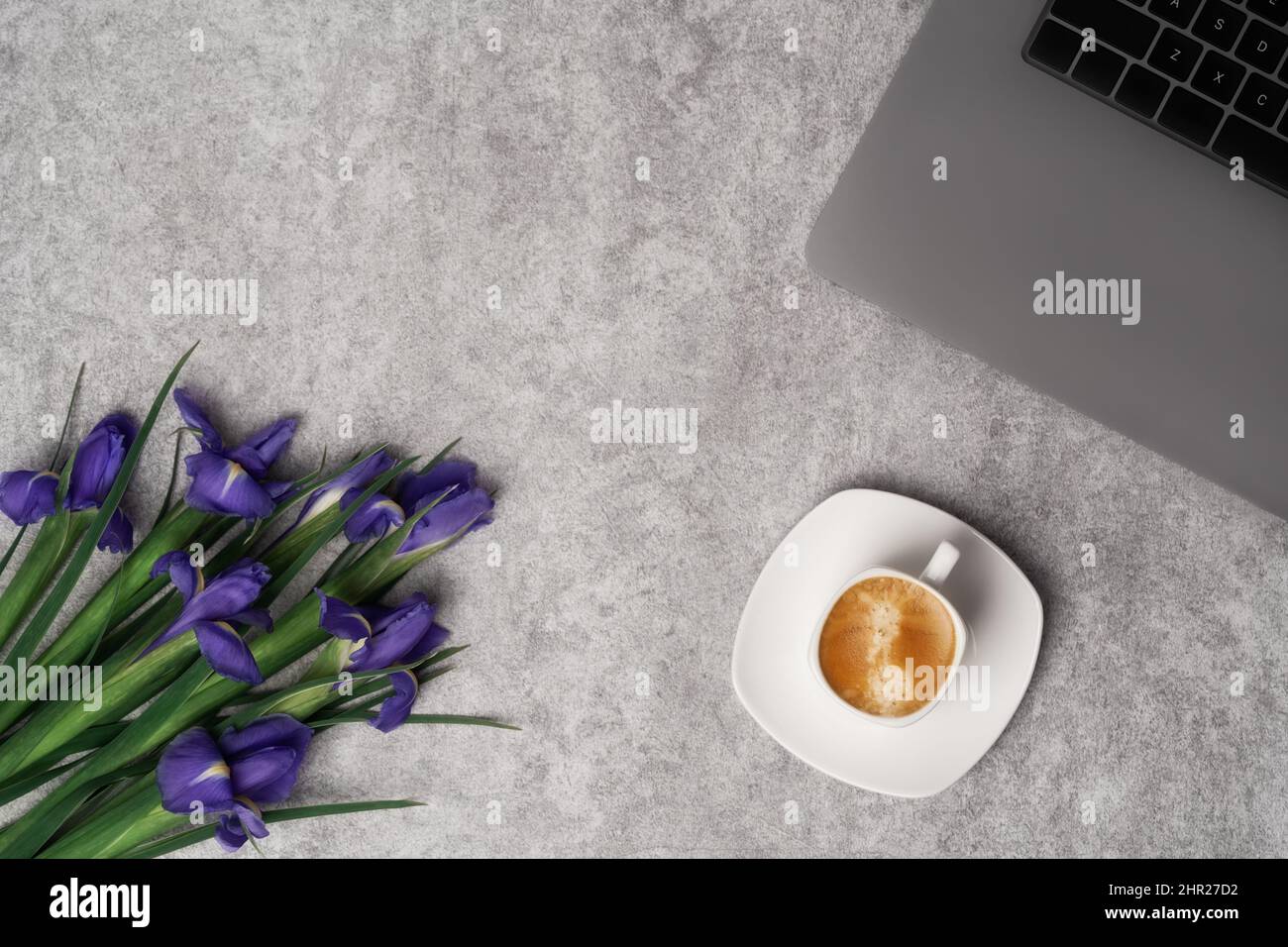 Spring women's workspace top view with beautiful iris flowers, laptop ...
