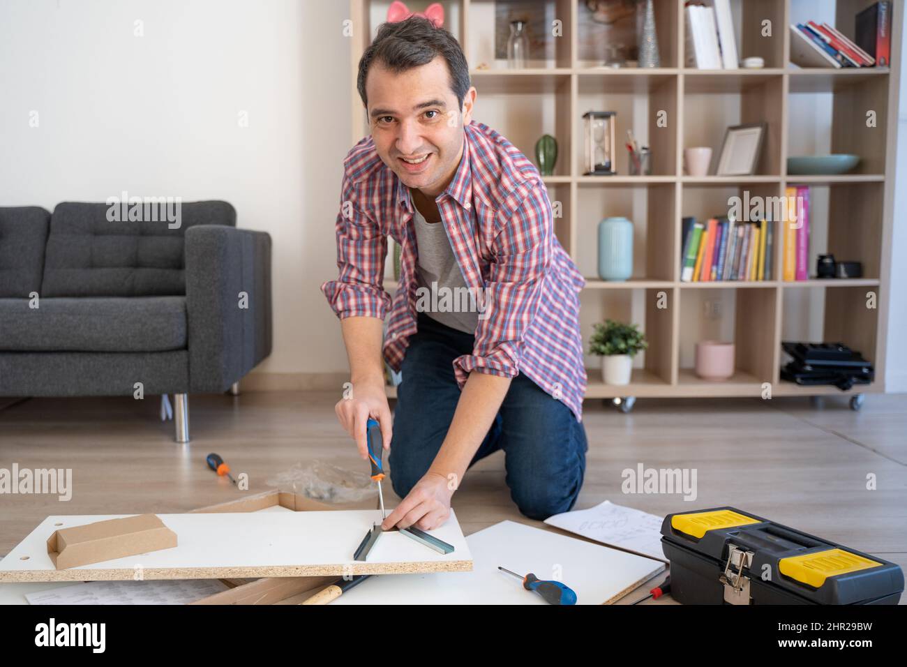 Concentrated man reading instructions to assemble furniture at home ...