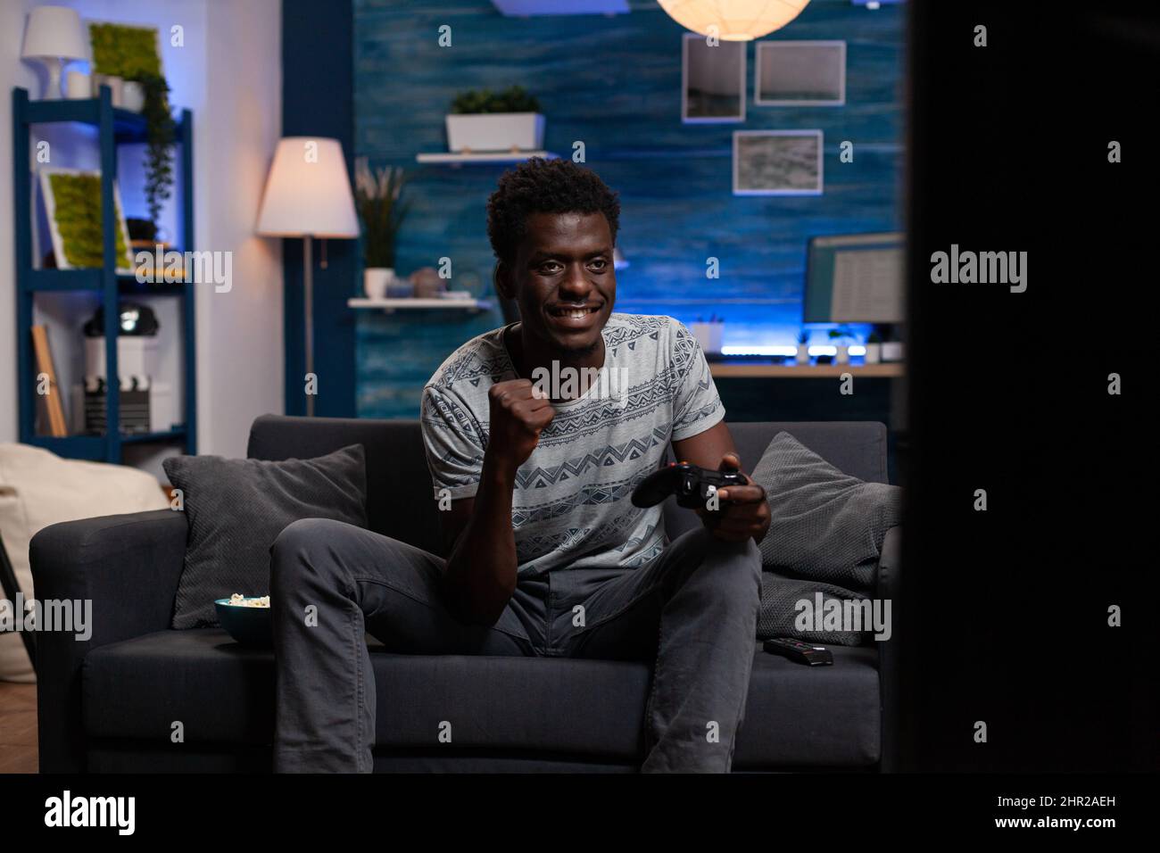 Happy excited pro gamer playing online video games using wireless ...