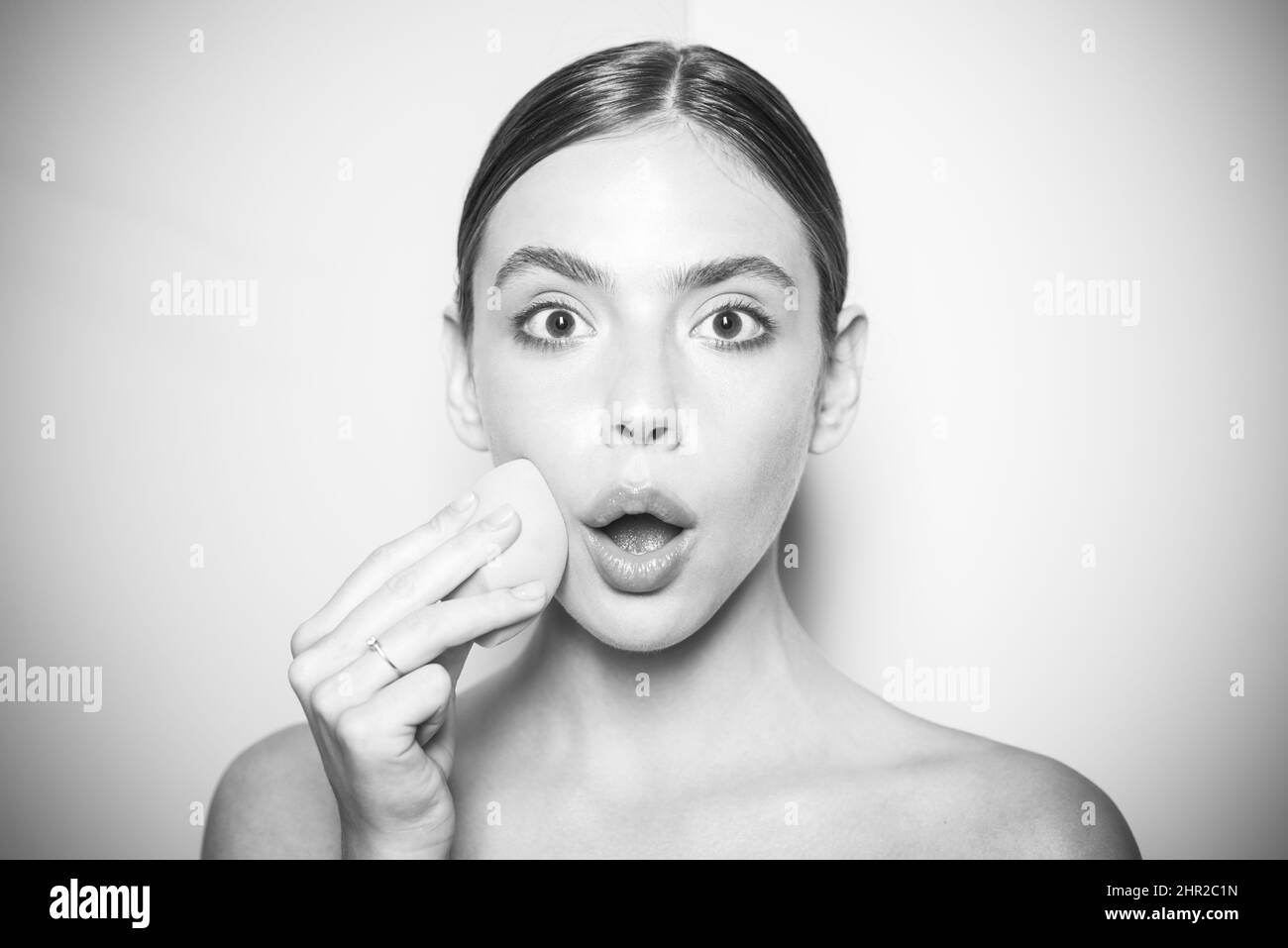 Beautiful girl applies natural makeup foundation with sponge. Perfect ...