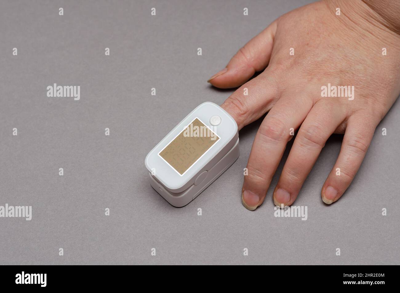 The oximeter is worn on the index finger of a woman's hand. A device ...