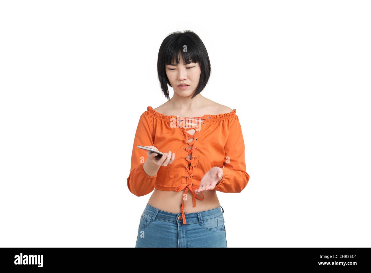 Young asian woman shrugging with her smartphone, isolated Stock Photo ...