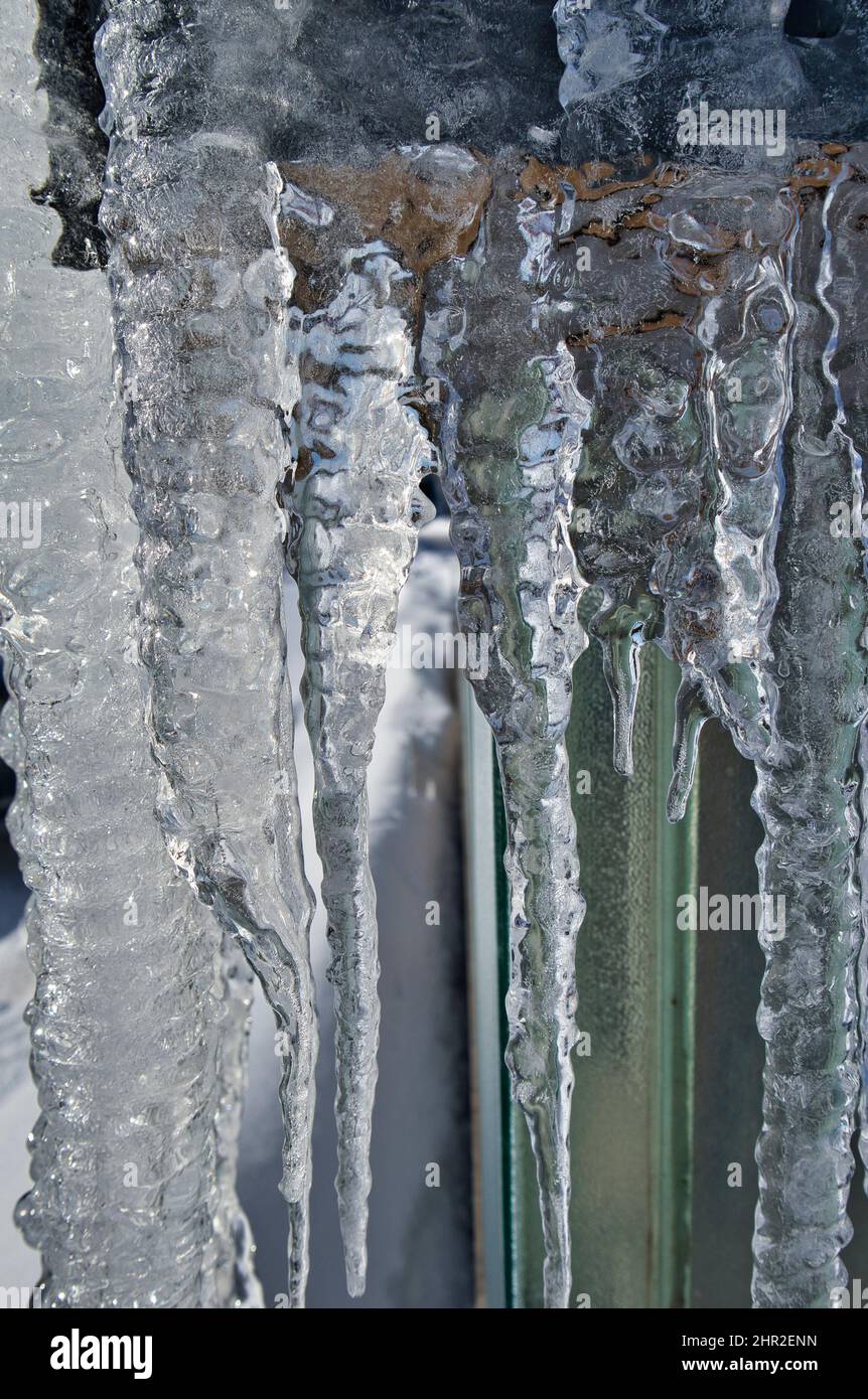 clear icicles hanging from the roof Stock Photo - Alamy