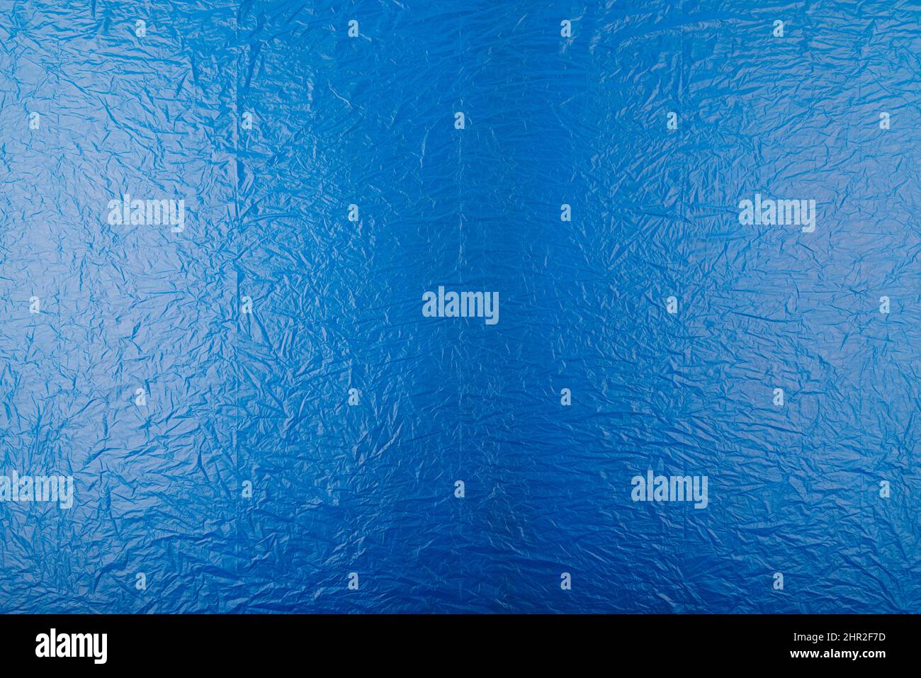 full frame flat background and texture of crumpled blue plastic film ...