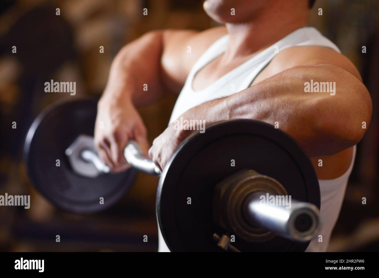 Workout with weights. A young man lifting a dumbbell at the gym Stock ...