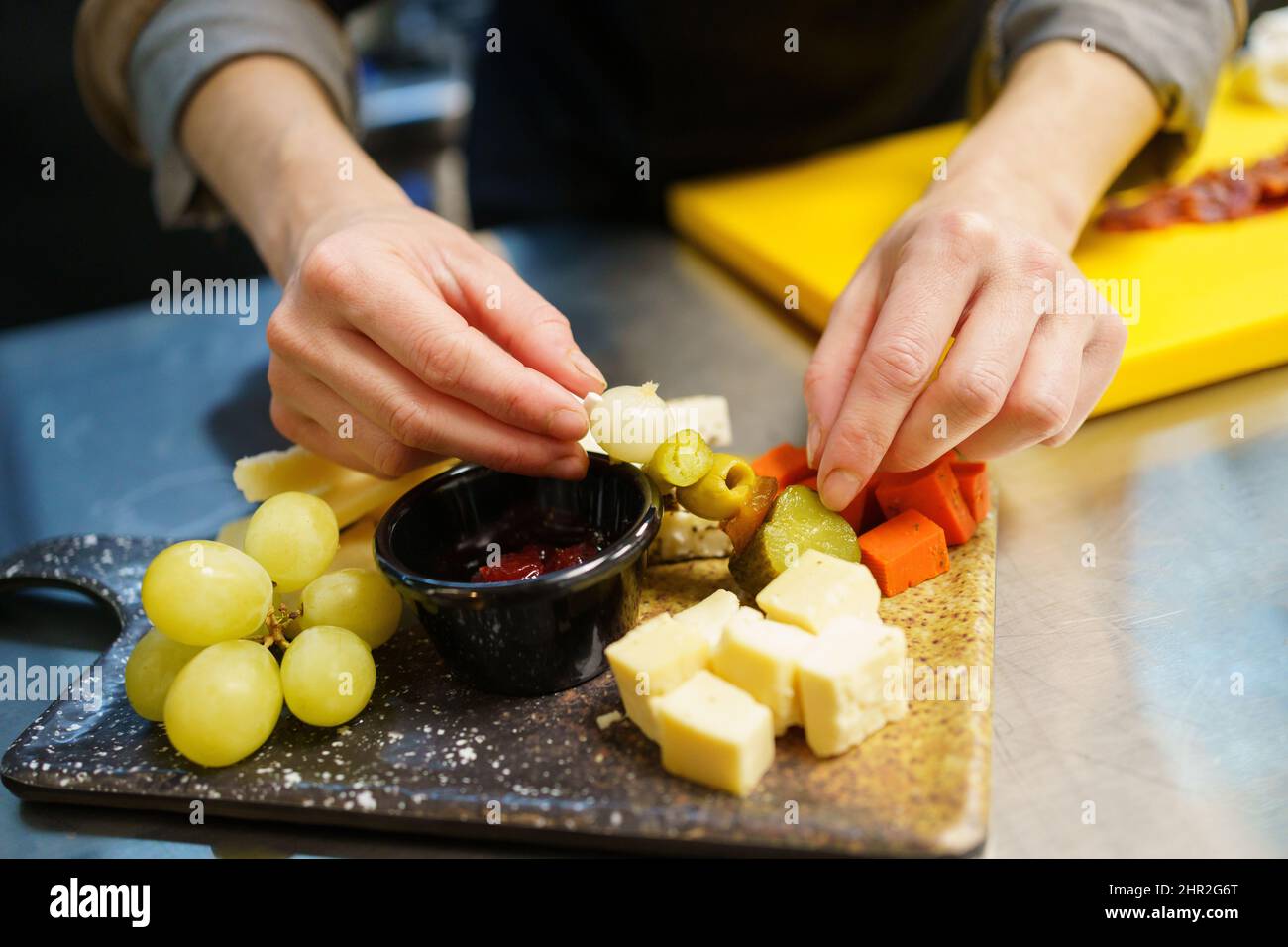 Crop cook arranging snacks on board Stock Photo - Alamy