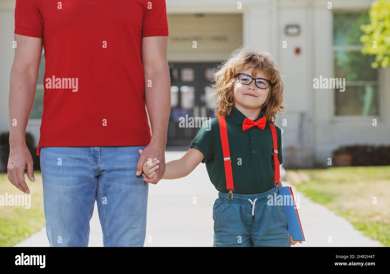 Portrait of happy nerd pupil holding teachers hand. School, family ...
