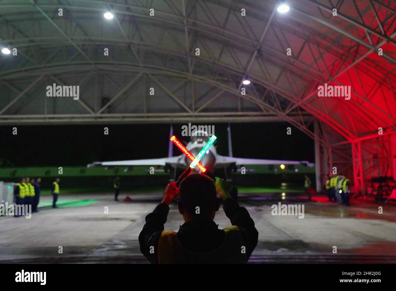 Crew officers and soldiers inspect fighter jets during night training ...